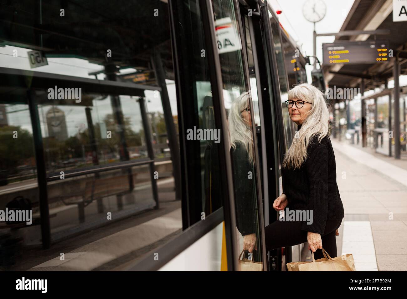 Mature woman entering bus Stock Photo - Alamy