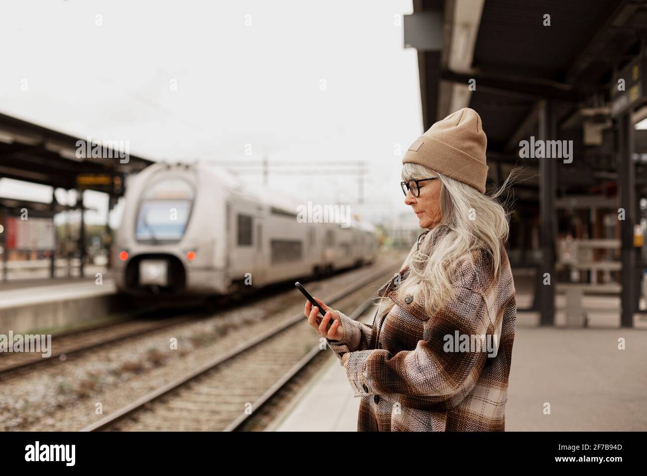 Mature woman at train station Stock Photo - Alamy