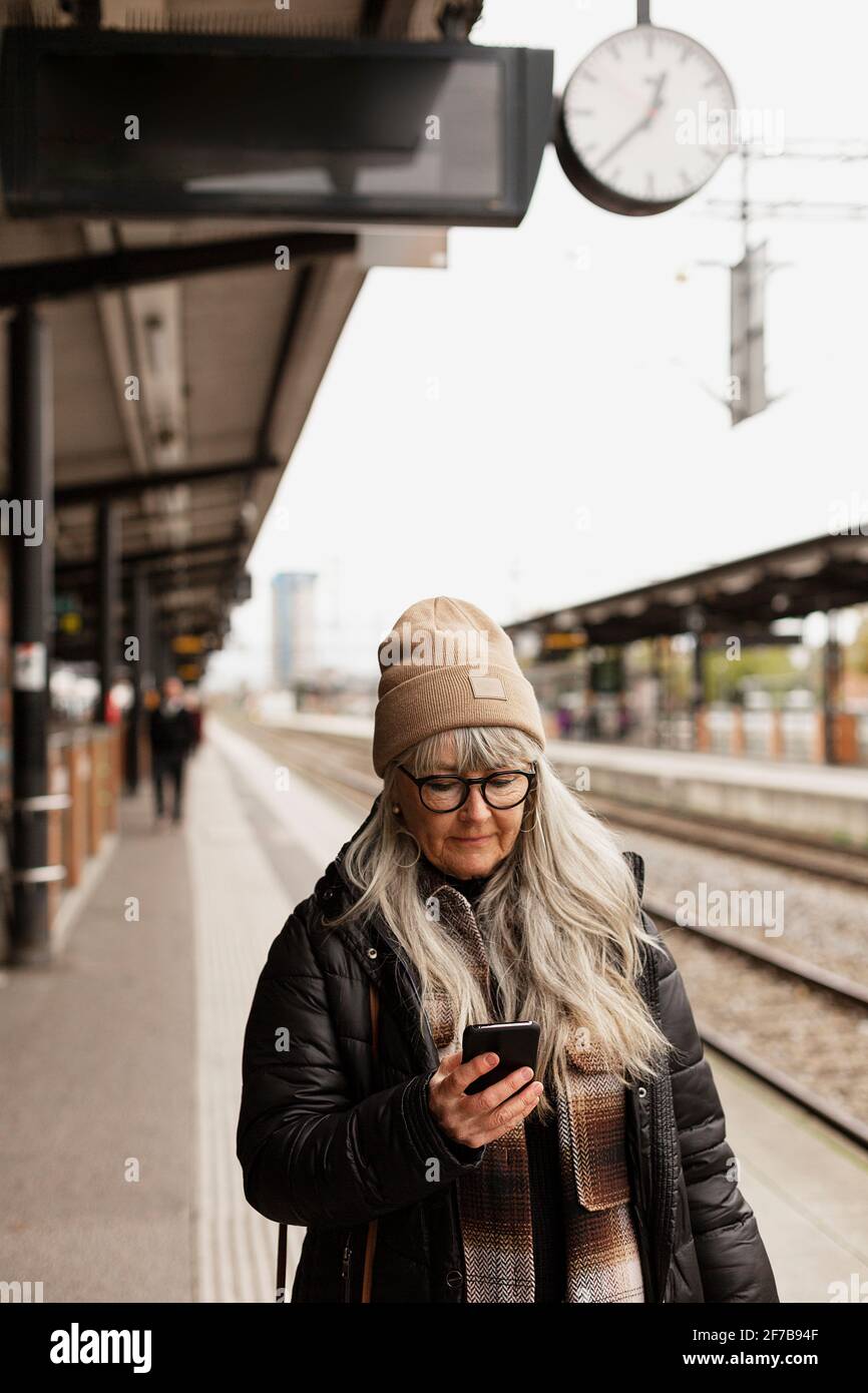Mature woman at train station Stock Photo - Alamy