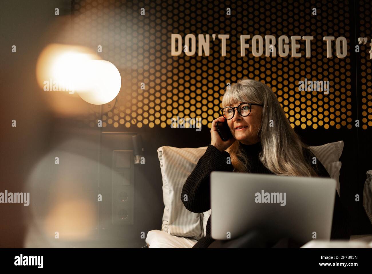 Woman using cell phone in hotel bed Stock Photo - Alamy