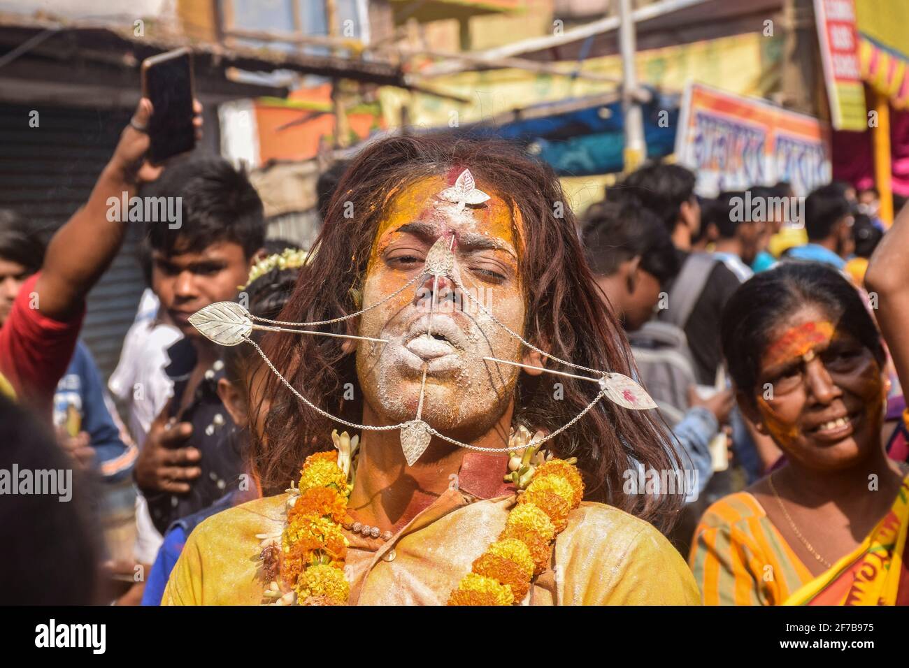A devotee pierces his cheeks and tongue with a skewer rod during the ...