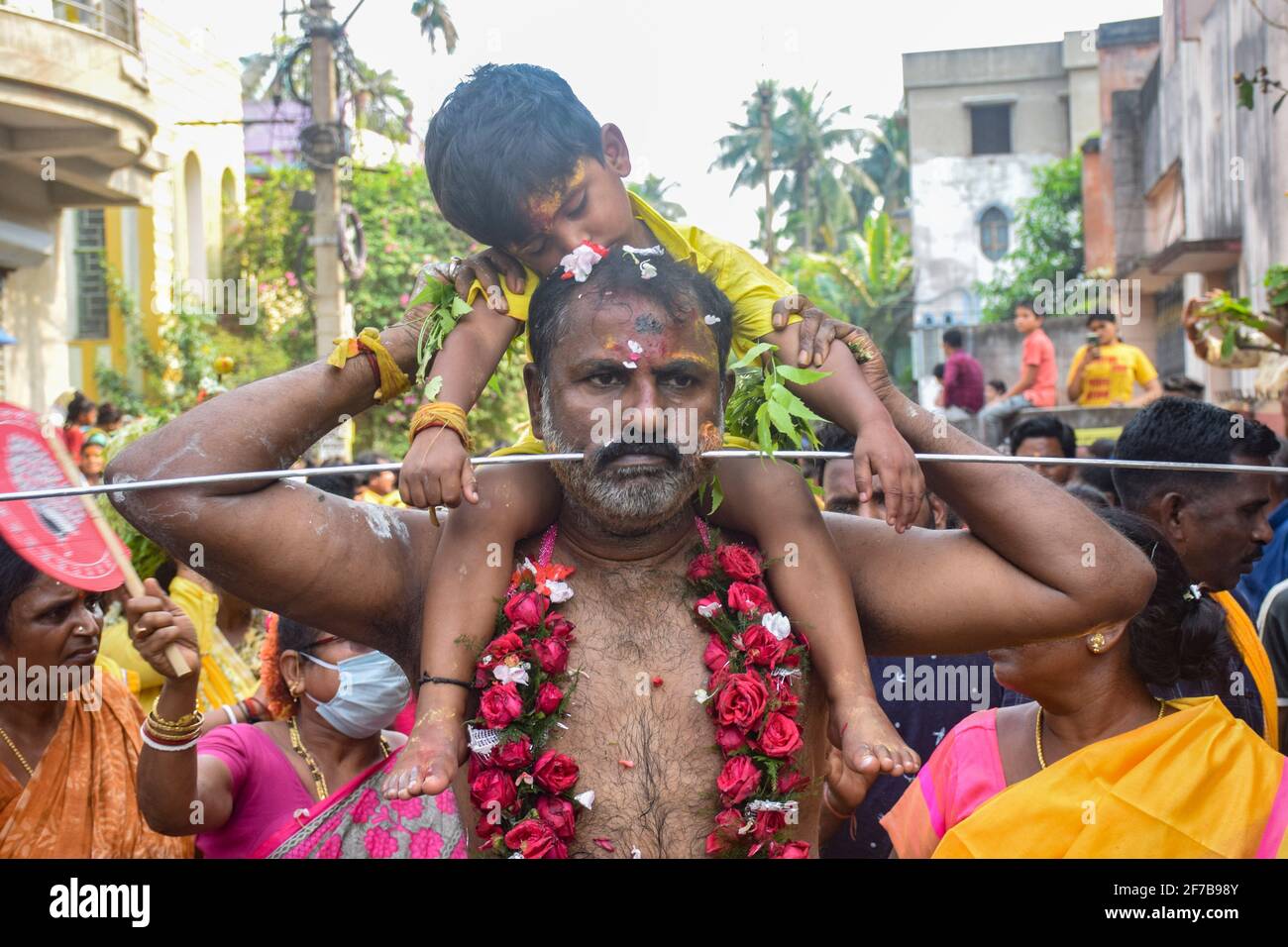 A devotee pierces his cheeks with a skewer rod during the festival ...