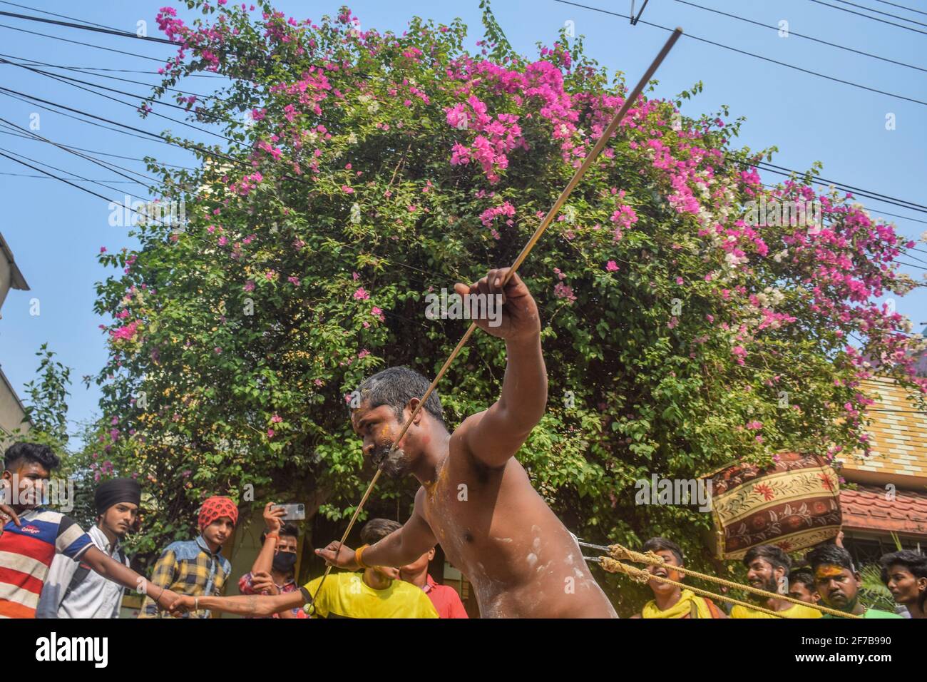 A devotee pierces his cheeks with a skewer rod during the festival ...