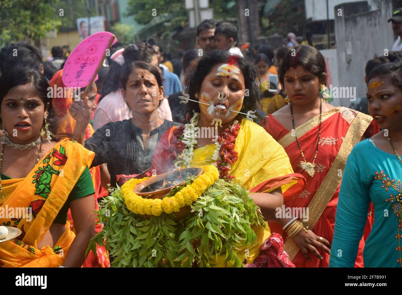 A devotee pierces his cheeks and tongue with a skewer rod during the ...