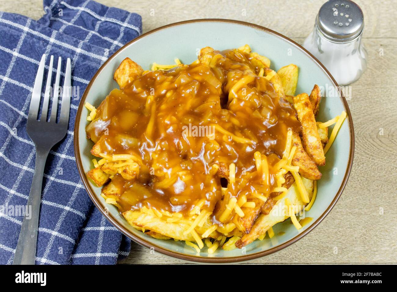 poutine in a dish on a table Stock Photo - Alamy