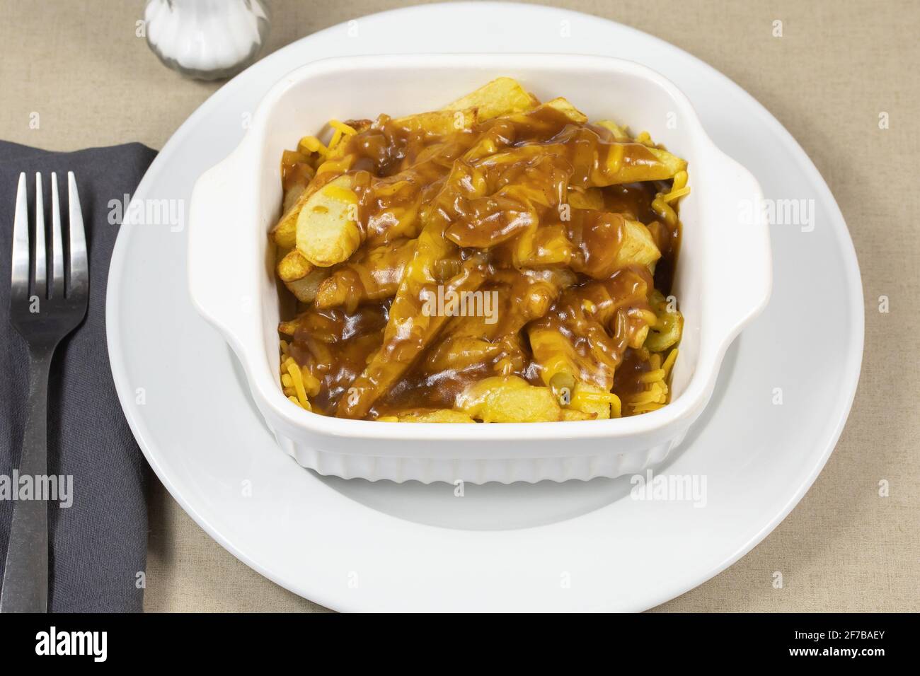 poutine in a dish on a table Stock Photo - Alamy