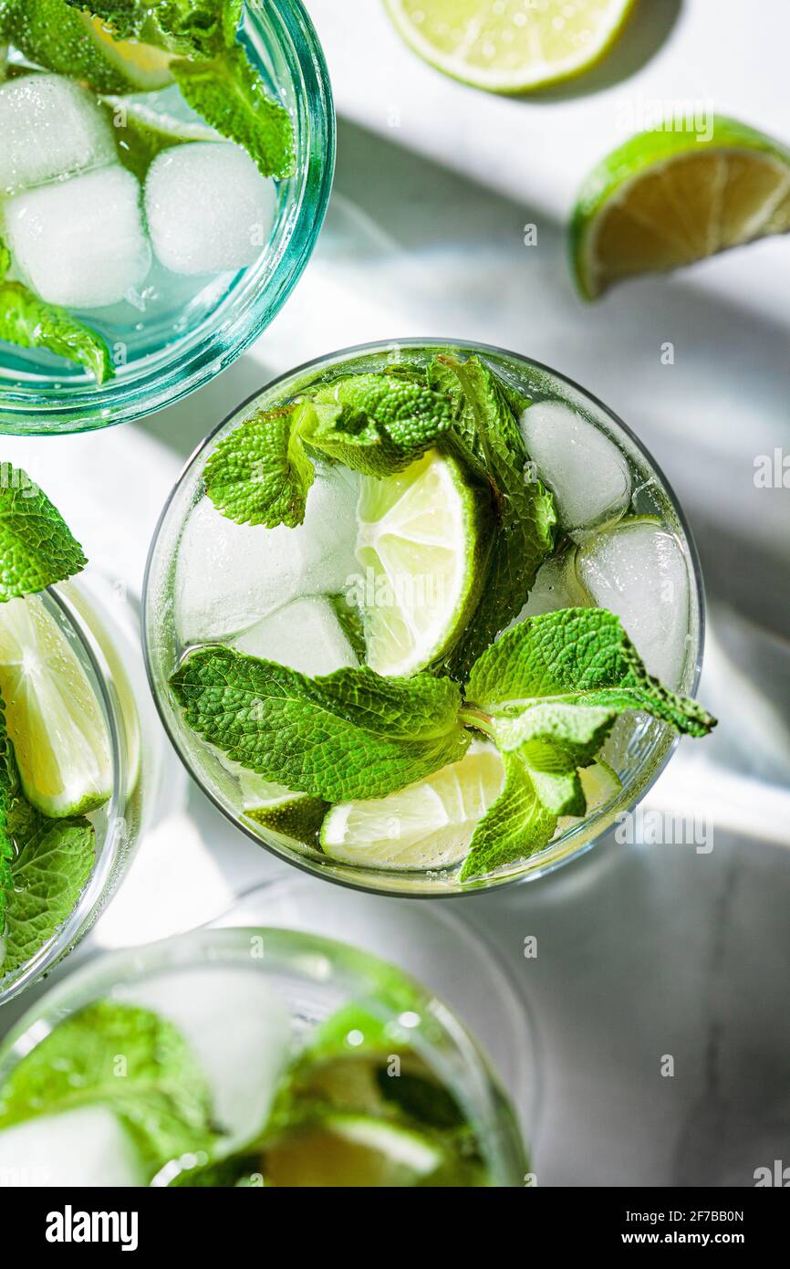 Mojito cocktail with mint and lime in different glasses, white marble ...
