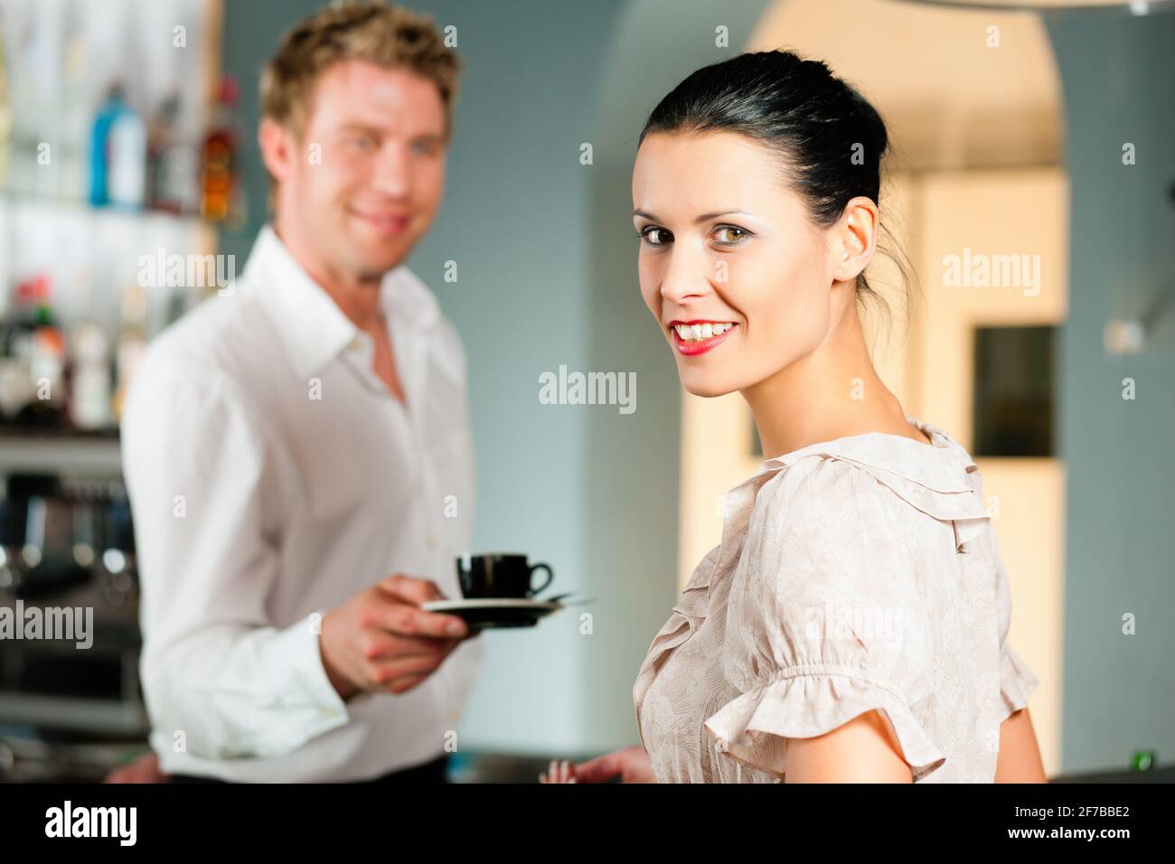 Coffeeshop - barista in cafe waits a coffee to a client Stock Photo - Alamy