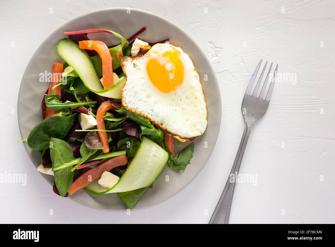 Fresh organic mesclun mix salad with cucumber, mozzarella and salmon ...