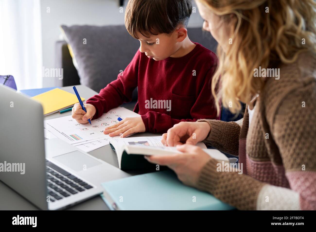 Mother helping her son with schoolwork Stock Photo - Alamy