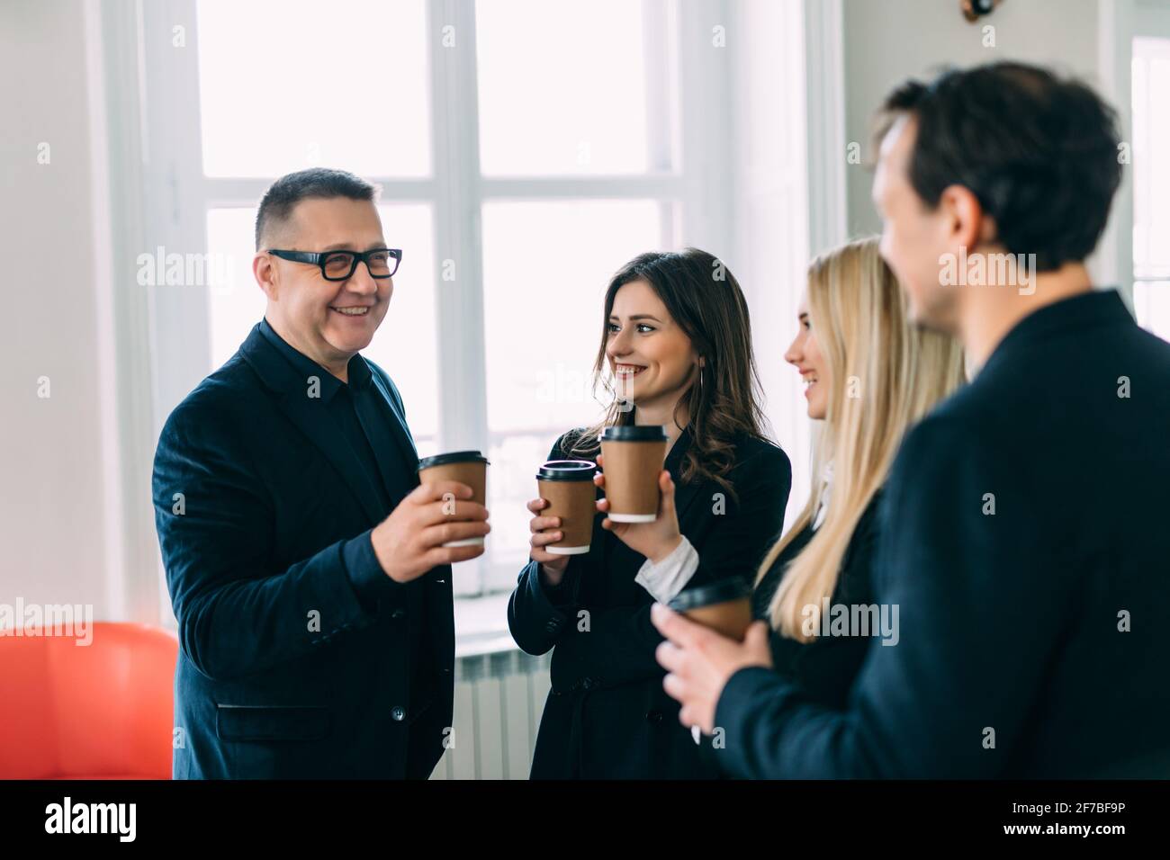Coworkers drinking coffee chatting workplace hi-res stock photography ...