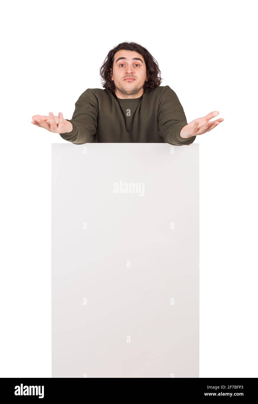 Perplexed and confused man, stands behind a blank banner, hands raised ...