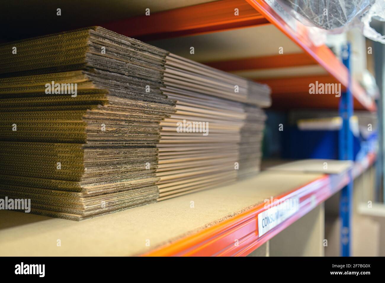 A selection of flat shipping boxes/cartons on a shelf ready to be made ...