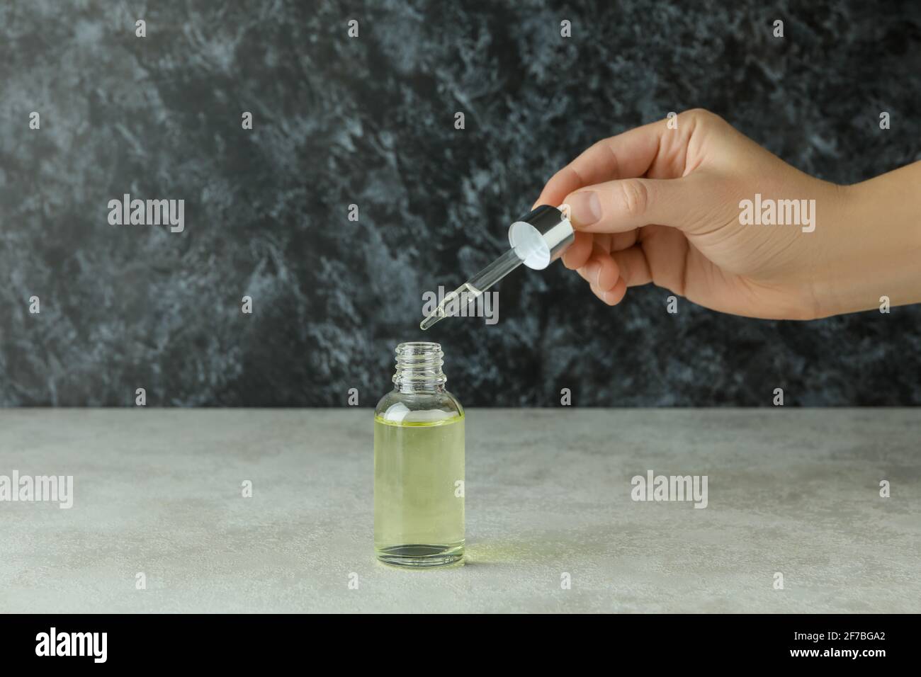 Concept of natural cosmetics with female hand dripping eucalyptus oil ...