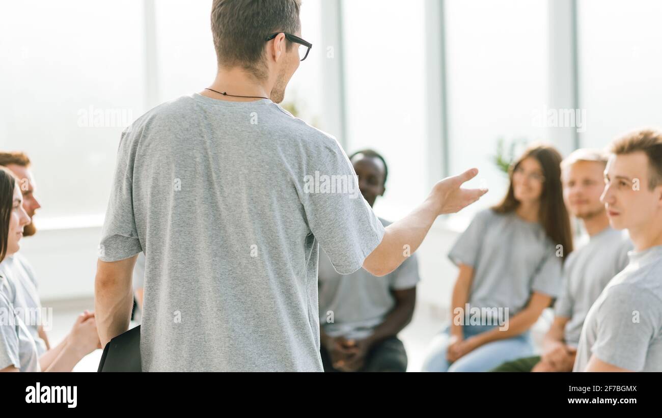 close up. business coach holds a debate with a group of young people ...