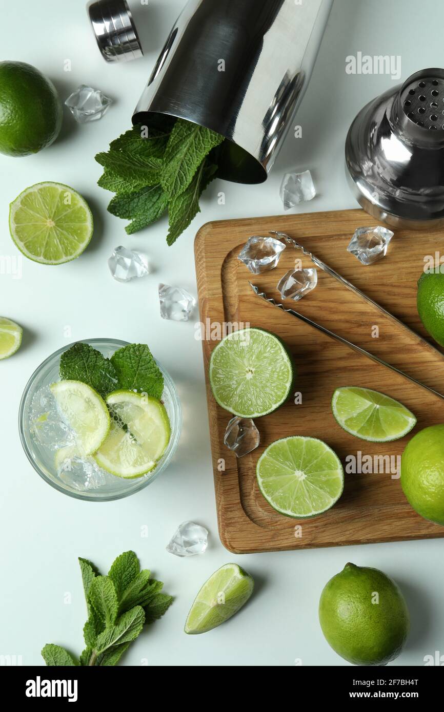 Glass of fresh mojito cocktail and ingredients on white background ...
