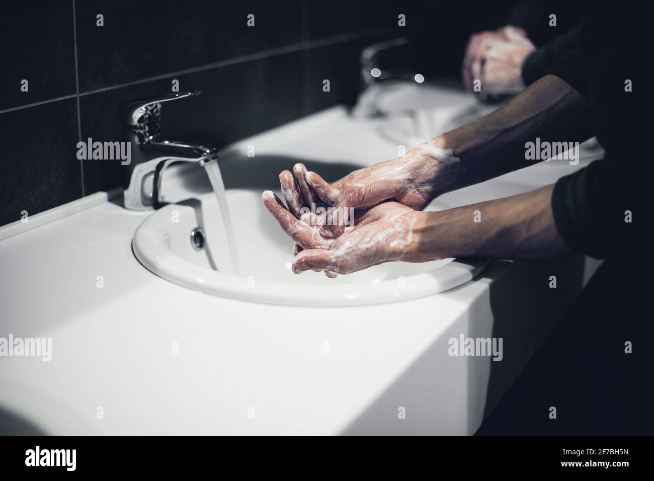close up. young people wash their hands in a public restroom Stock ...