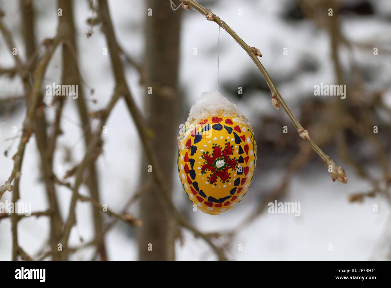 cold and snowy easter holidays with colored and painted hanging easter ...