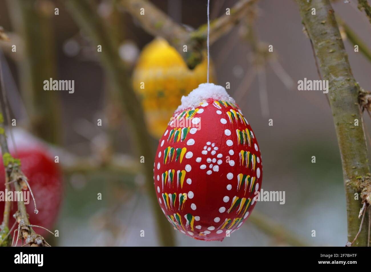 cold and snowy easter holidays with colored and painted hanging easter ...