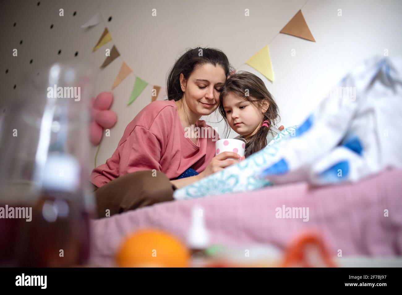 Mother looking after sick small daughter in bed at home Stock Photo - Alamy