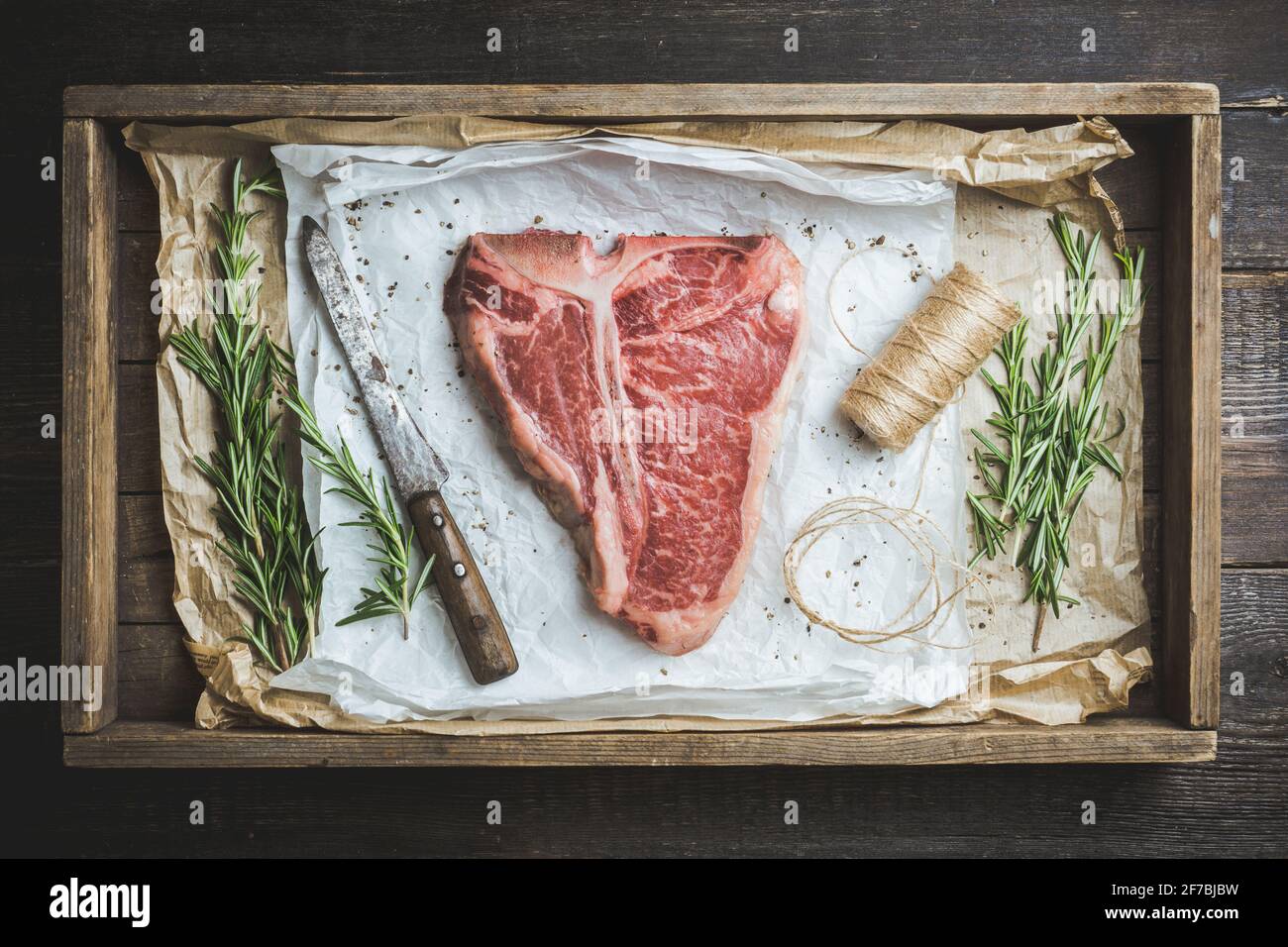 Raw fresh marble T-bone meat on the rustic background. Selective focus ...