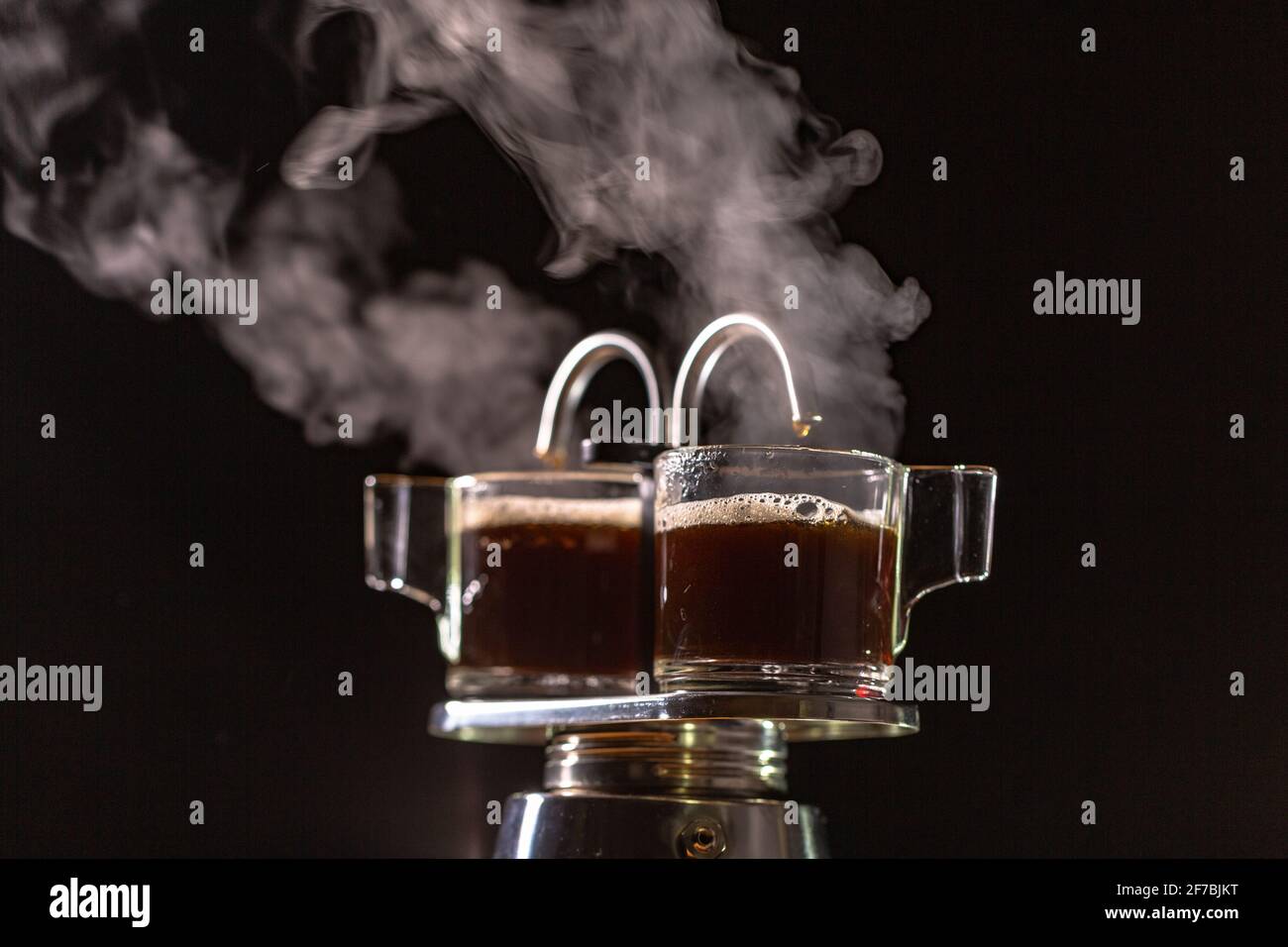 Heat vapor emitted from the coffee machine. Two black coffeemakers in a ...