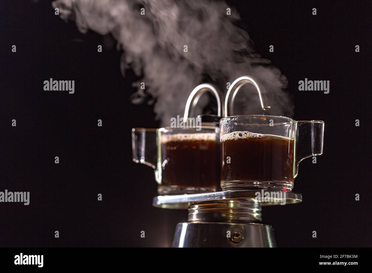 Heat vapor emitted from the coffee machine. Two black coffeemakers in a ...