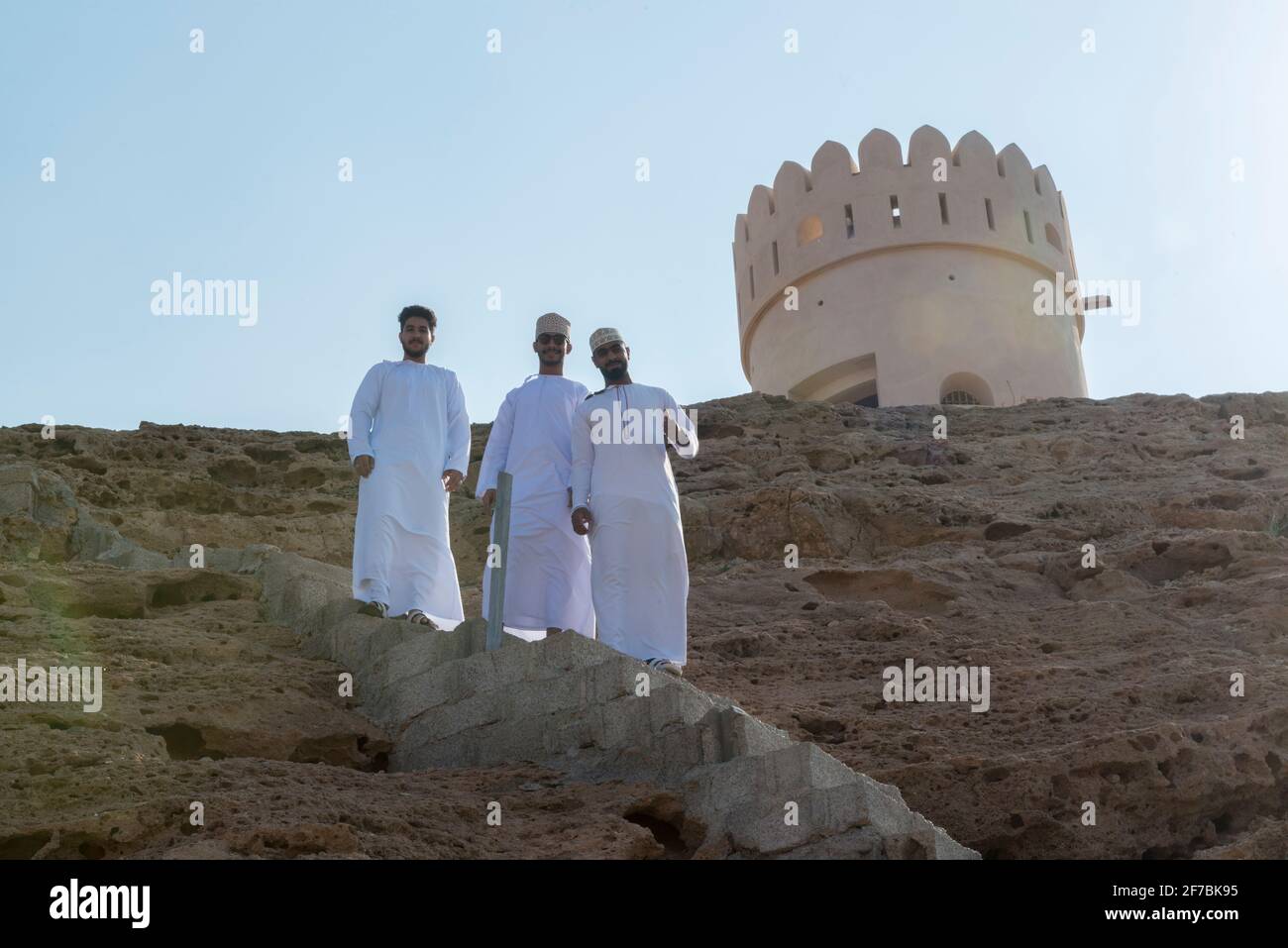 Three Omani men descending from the Al Ayjah watchtower, Sur, Oman ...