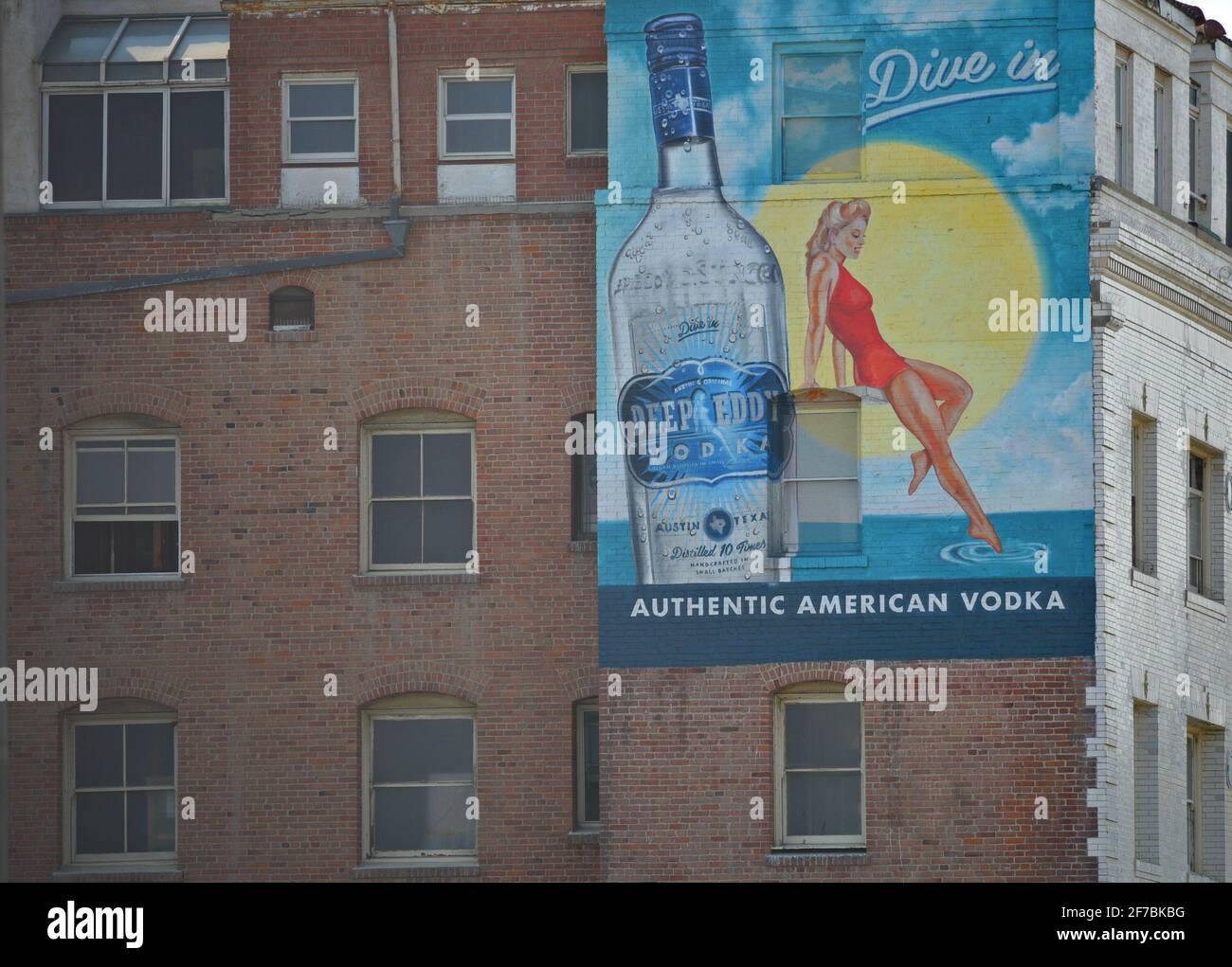 Old residential building brick wall with a vodka mural advertisement in ...