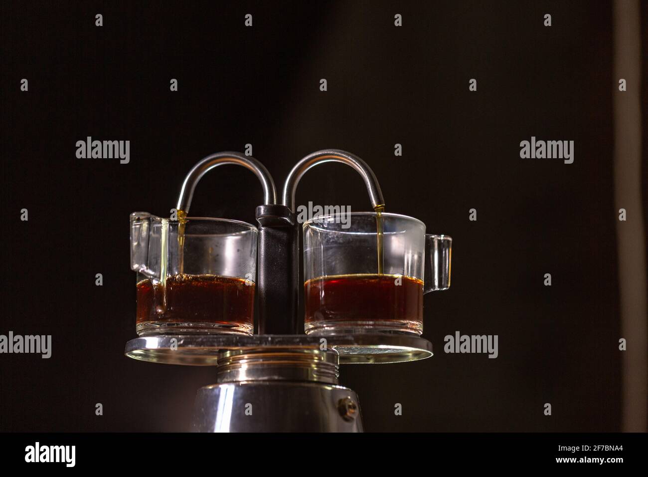 Heat vapor emitted from the coffee machine. Two black coffeemakers in a ...