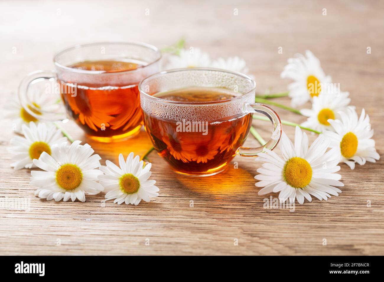 cups of chamomile tea with fresh chamomile flowers on a wooden table Stock Photo - Alamy