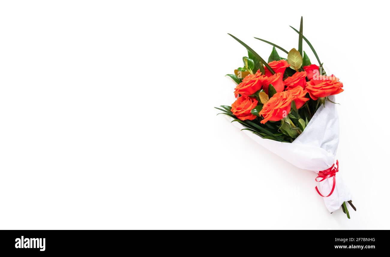 Flat lay. Bouquet of red roses and green leaves on a white background ...