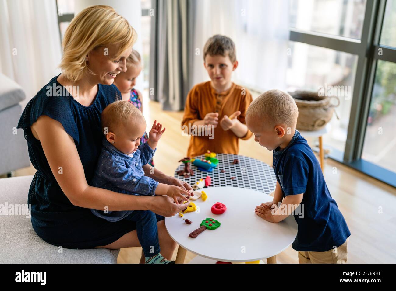 Family, children, education, happiness concept. Mother teaches ...
