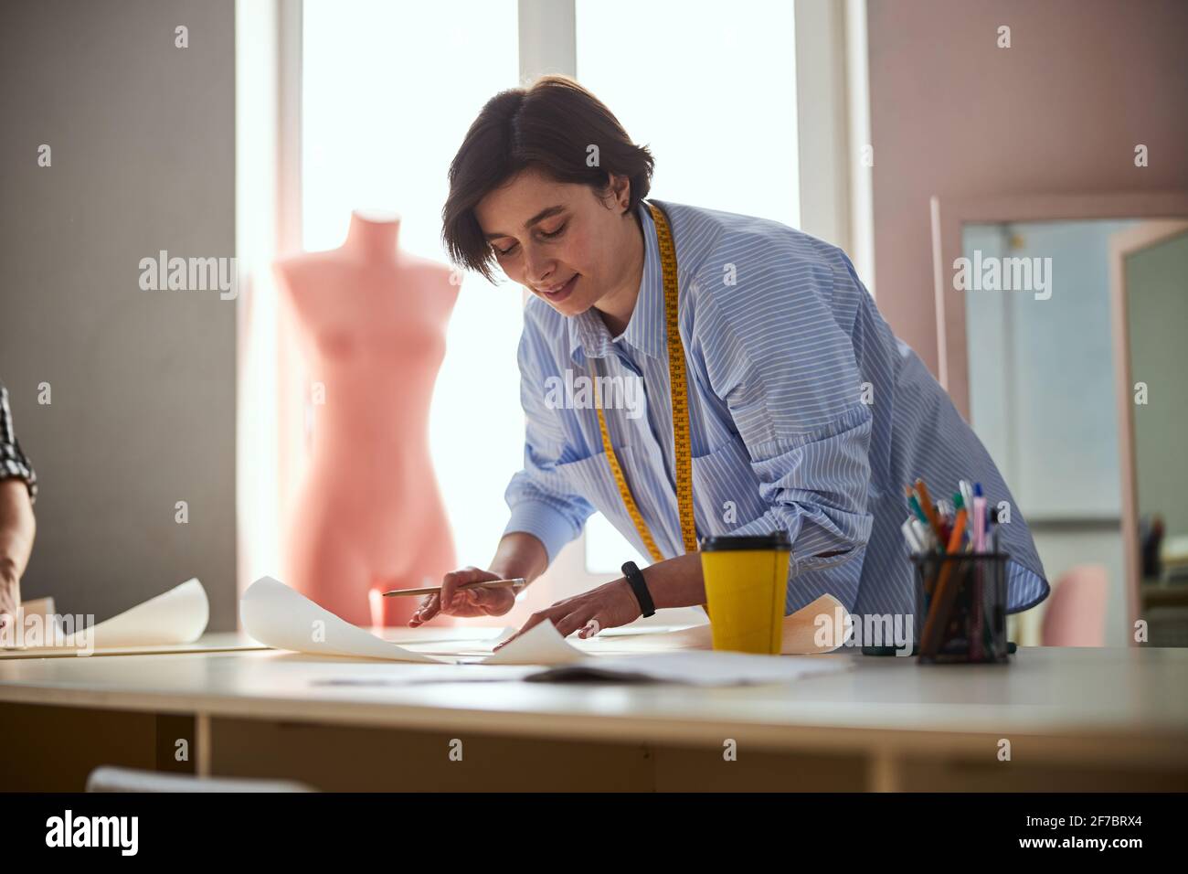 Tailor creating a dress design on paper piece Stock Photo - Alamy