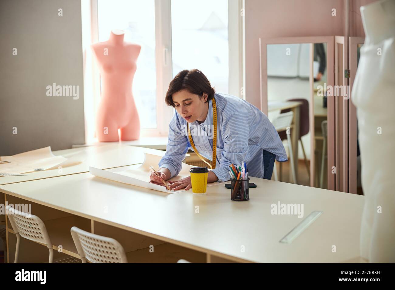 Tailor drawing with pencil on paper sheet Stock Photo - Alamy