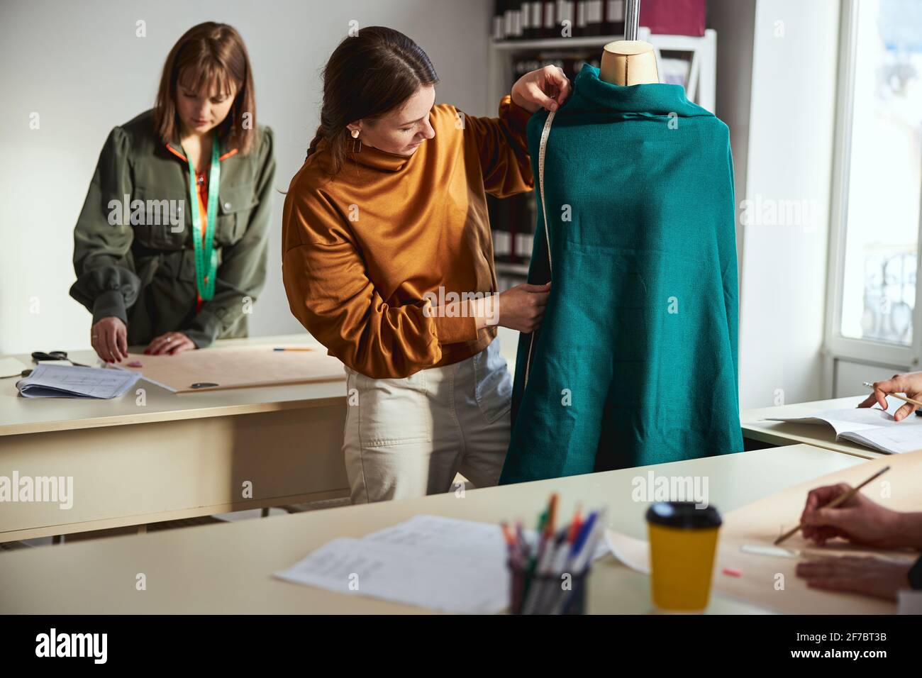Measuring of dress length by a female fashion designer Stock Photo - Alamy