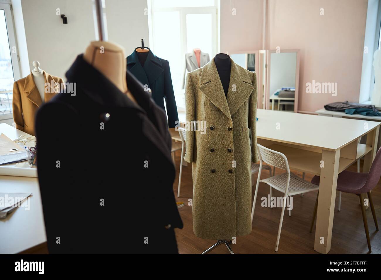 Empty workshop with finished clothes on tailor stands Stock Photo - Alamy