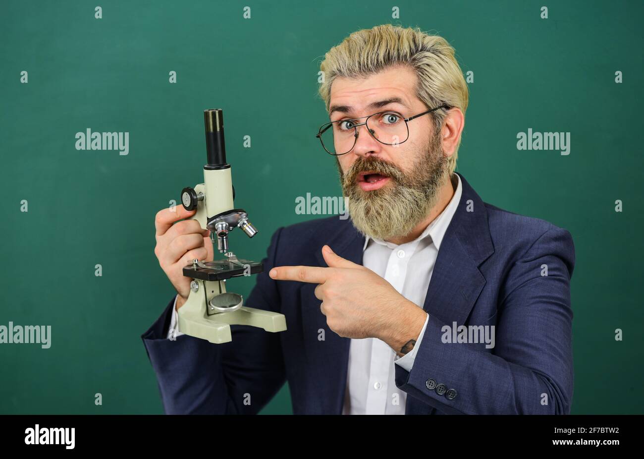 School teacher looking microscope. Biological research. Facilitate ...