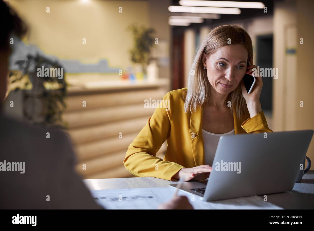 Busy blonde female looking at screen of her laptop Stock Photo - Alamy
