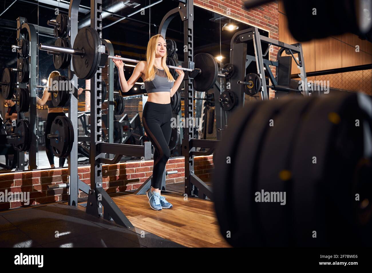 Strong slim woman posing with barbell at the gym Stock Photo - Alamy