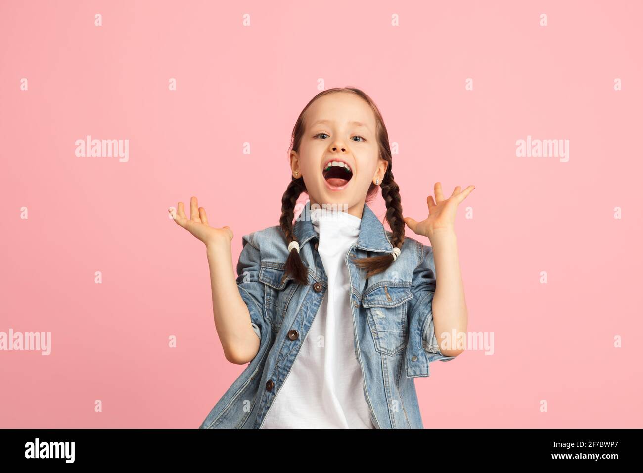 Happy kid, girl isolated on pink studio background. Looks happy ...