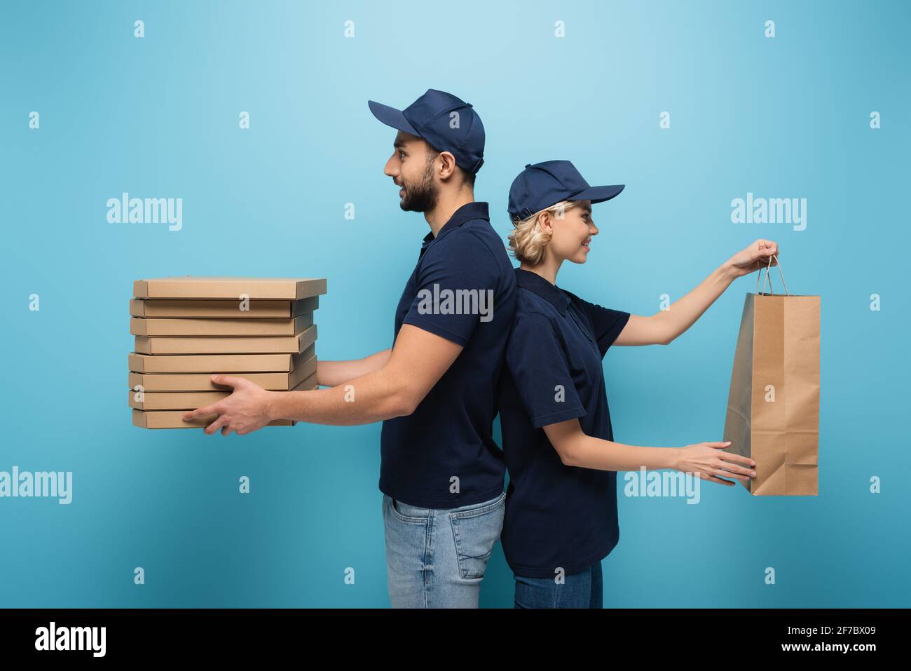 arabian delivery man standing back to back with colleague with paper ...