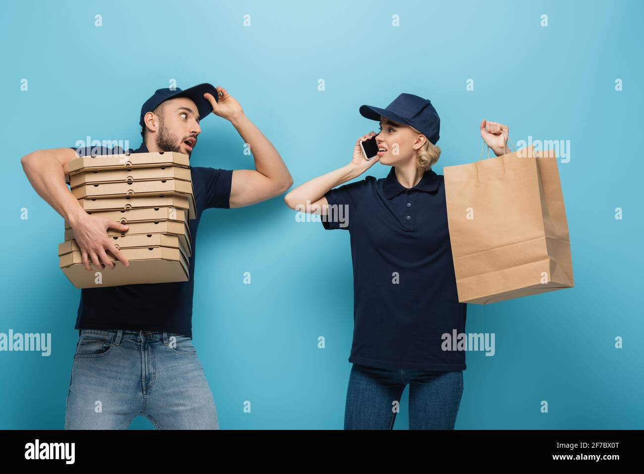 shocked muslim delivery man looking at colleague accepting order on ...