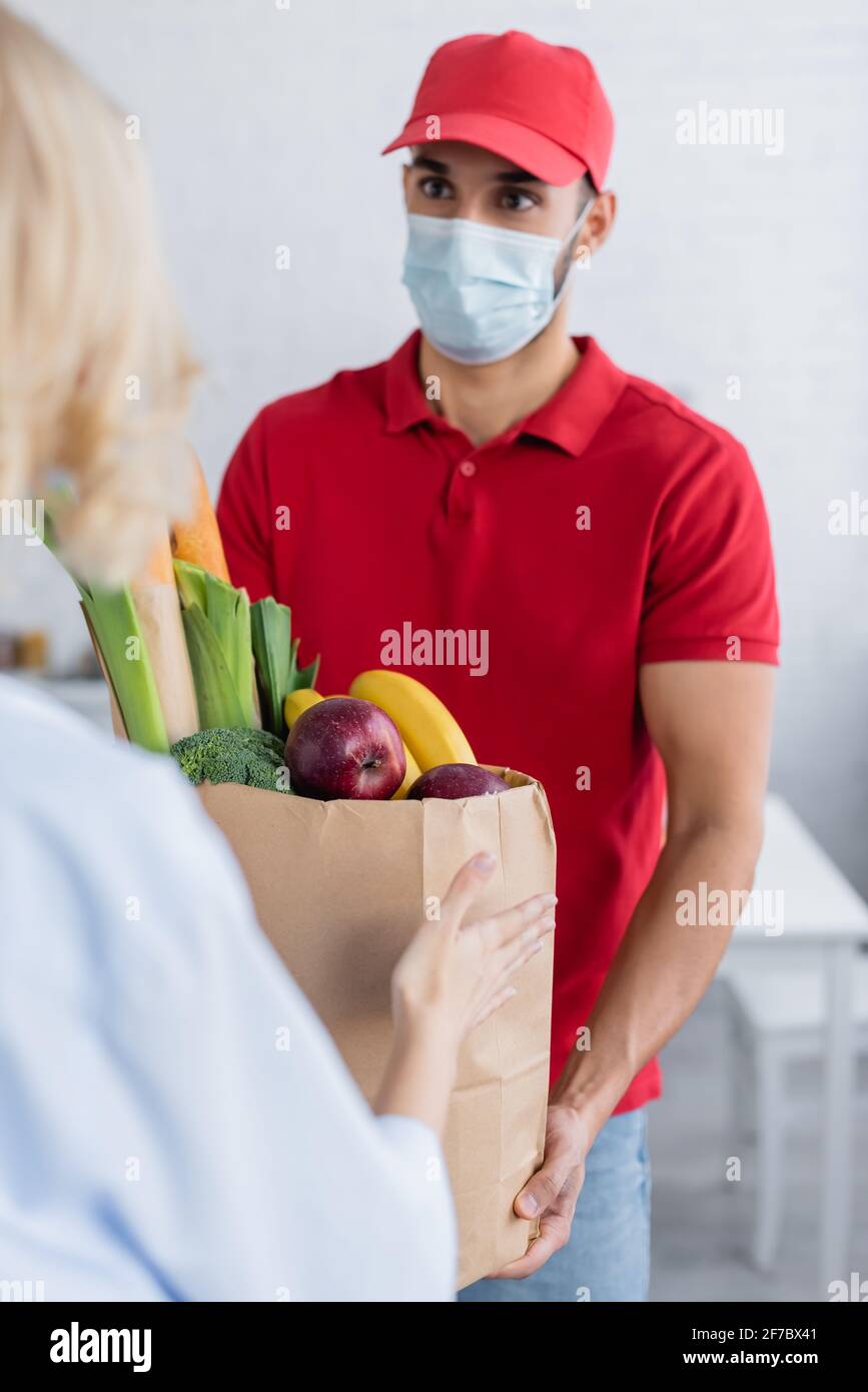 muslim delivery man in medical mask holding fresh food in paper bag ...