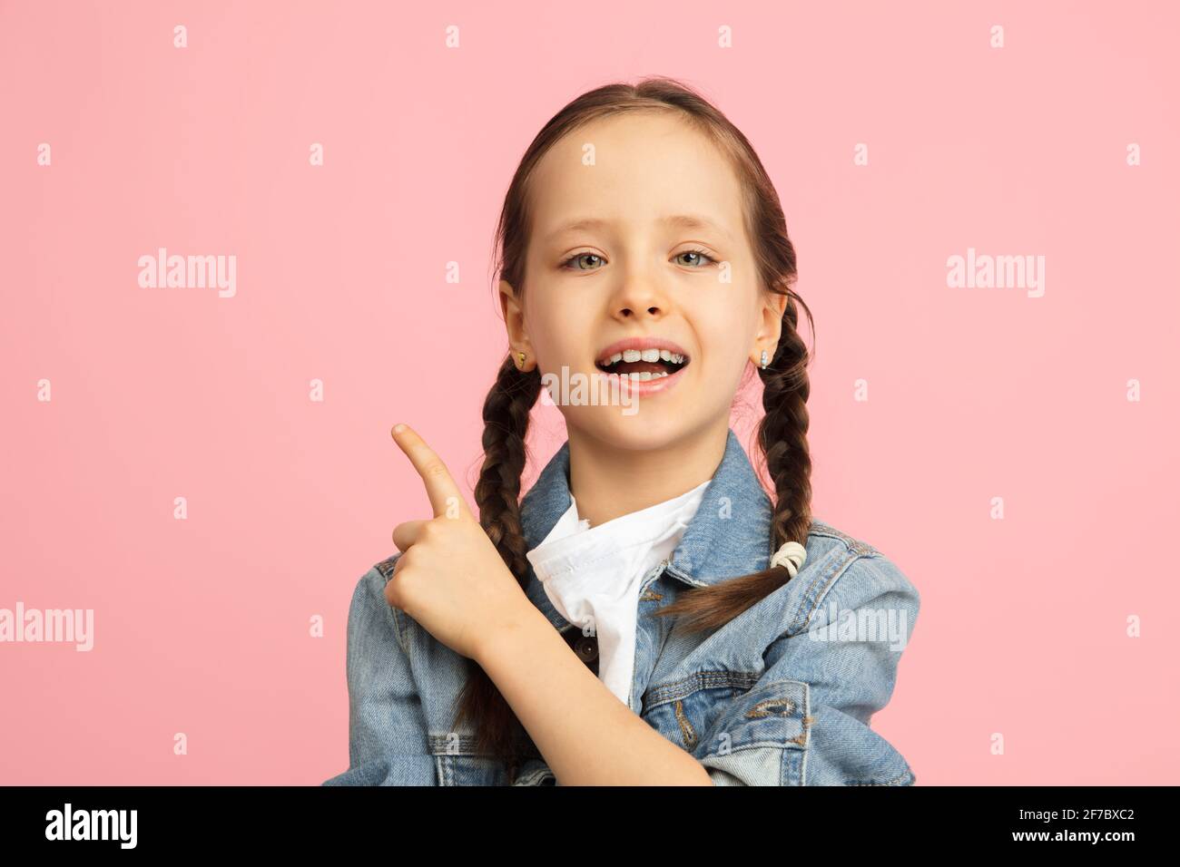 Happy kid, girl isolated on pink studio background. Looks happy ...