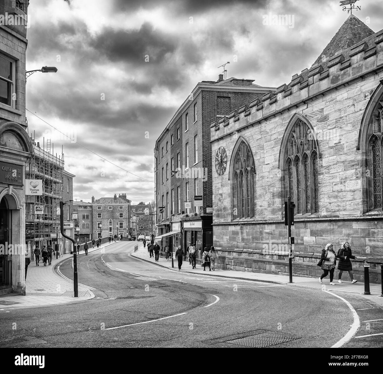 A city street curving around a corner and leading to a bridge. A gothic ...