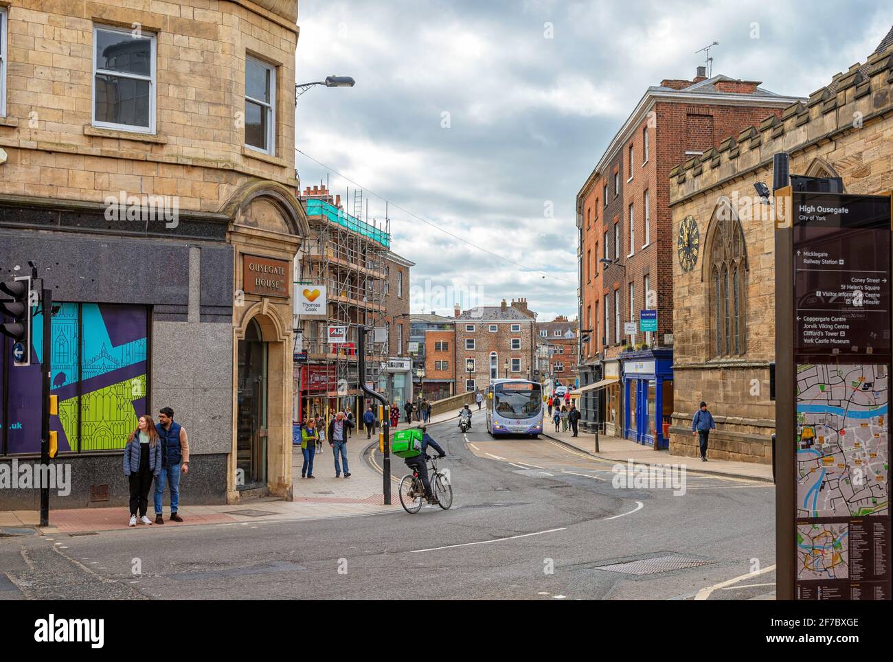 A city street curving around a corner and leading to a bridge. A gothic ...