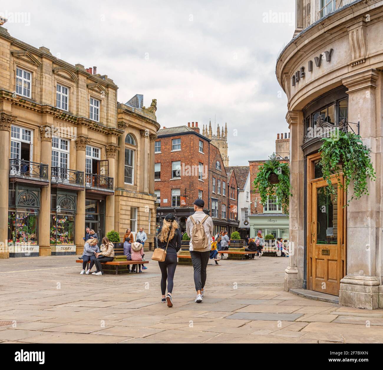 Public square with historic buildings and people sat on benches. Two ...