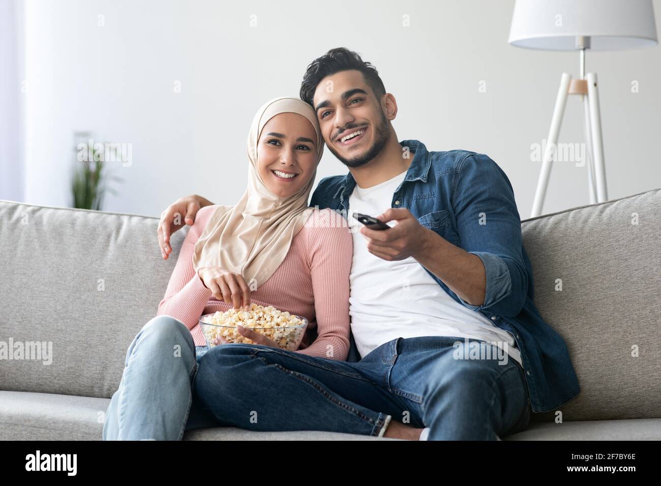 Happy muslim family watching TV together at home Stock Photo - Alamy