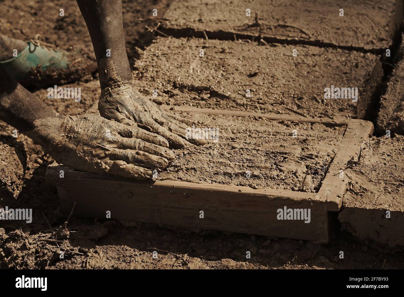 Close up of hands making traditional adobe mud bricks - worker make ...